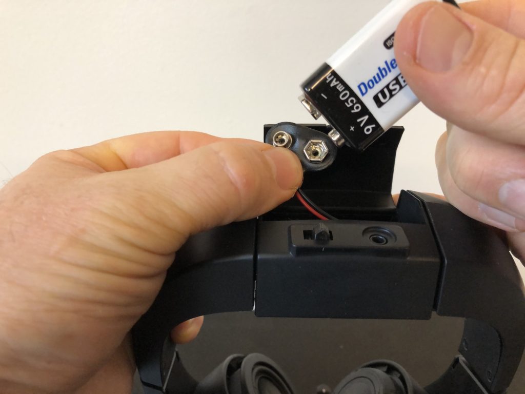 Load the battery into the compartment with the battery terminals located on